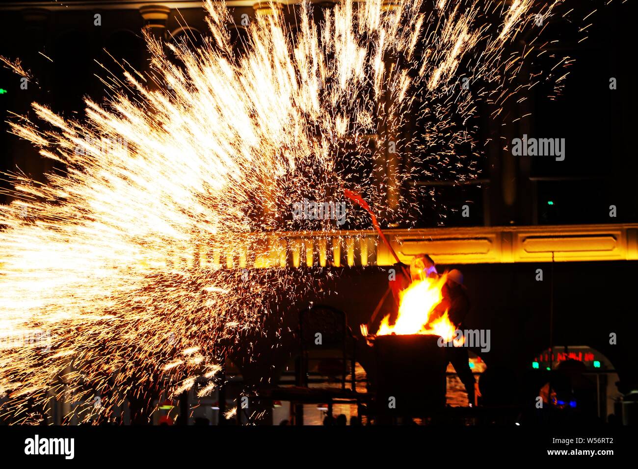 Performers spray molten iron water to create sparks into the sky during ...