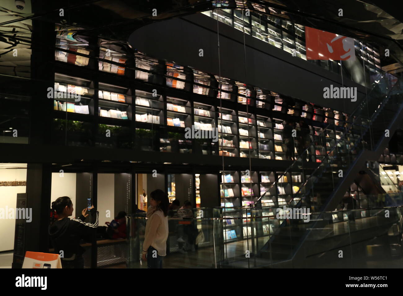 Books are placed on the four-storey-high book wall with a height of 18 ...