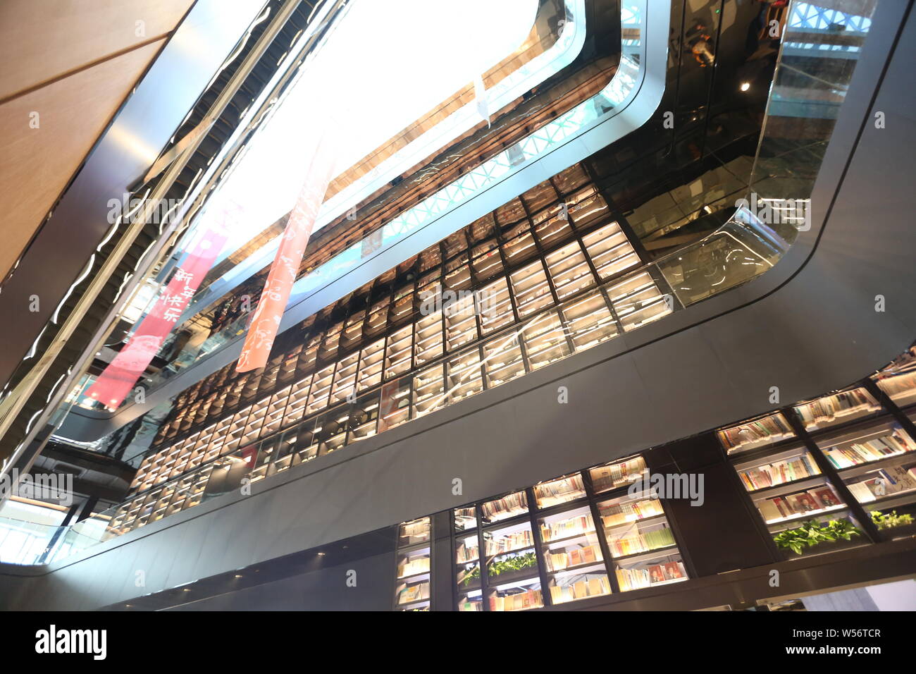 Books are placed on the four-storey-high book wall with a height of 18 ...