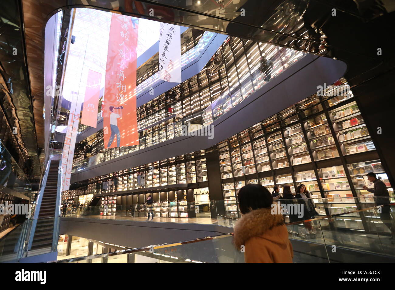 Books are placed on the four-storey-high book wall with a height of 18 ...