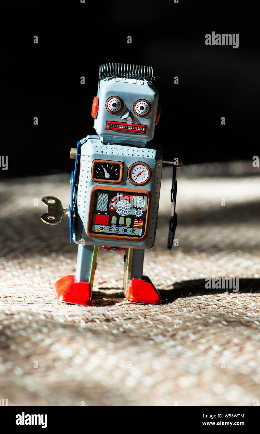 Vintage metal blue robot toy on sunlight. Futuristic concept with small ...