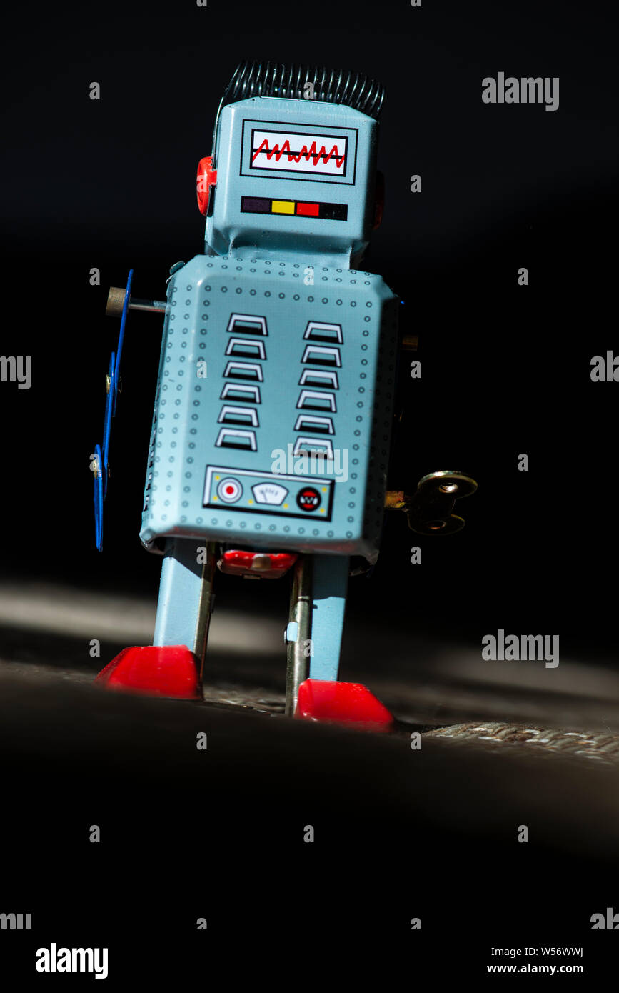 Vintage metal blue robot toy on sunlight. Futuristic concept with small ...