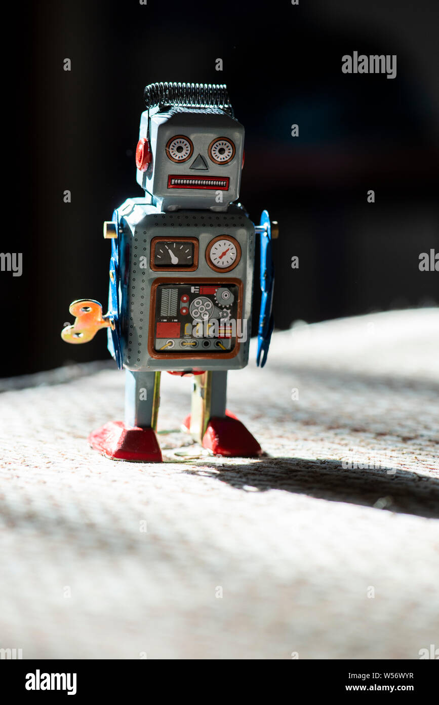 Vintage metal blue robot toy on sunlight. Futuristic concept with small ...