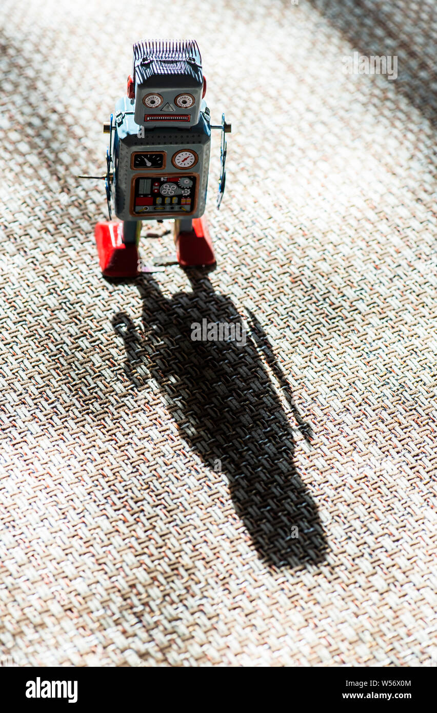 Vintage metal blue robot toy on sunlight. Futuristic concept with small ...