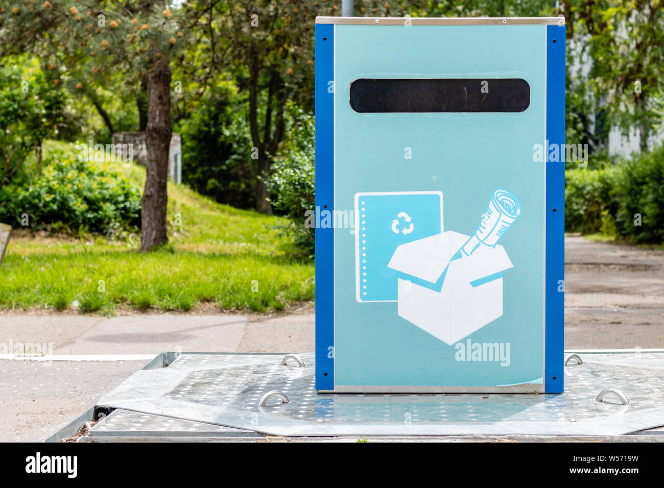Blue recycle bin with paper recycle symbol, on the sidewalk Stock Photo ...