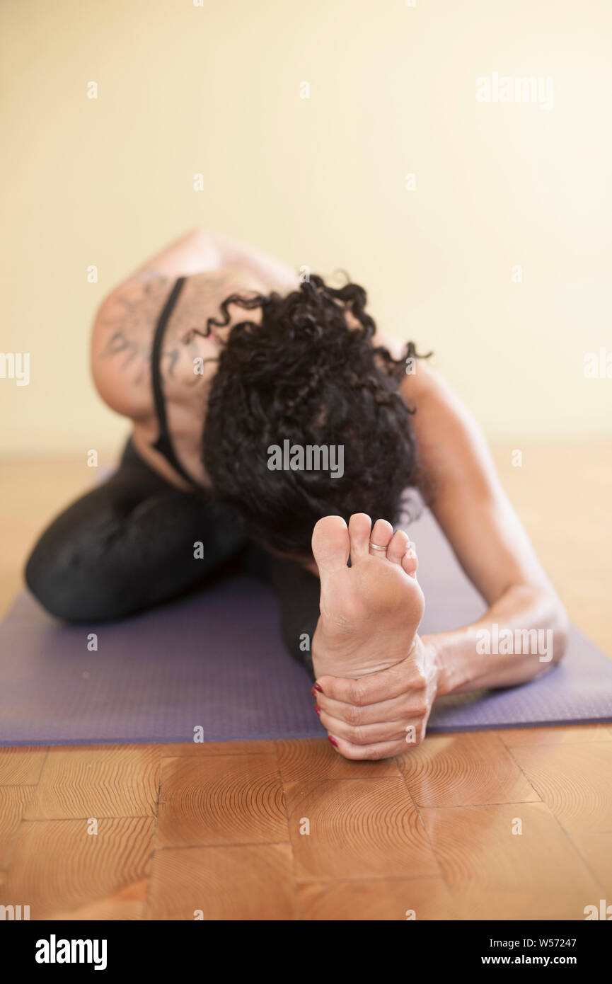 Woman in a yoga bound forward fold Stock Photo - Alamy