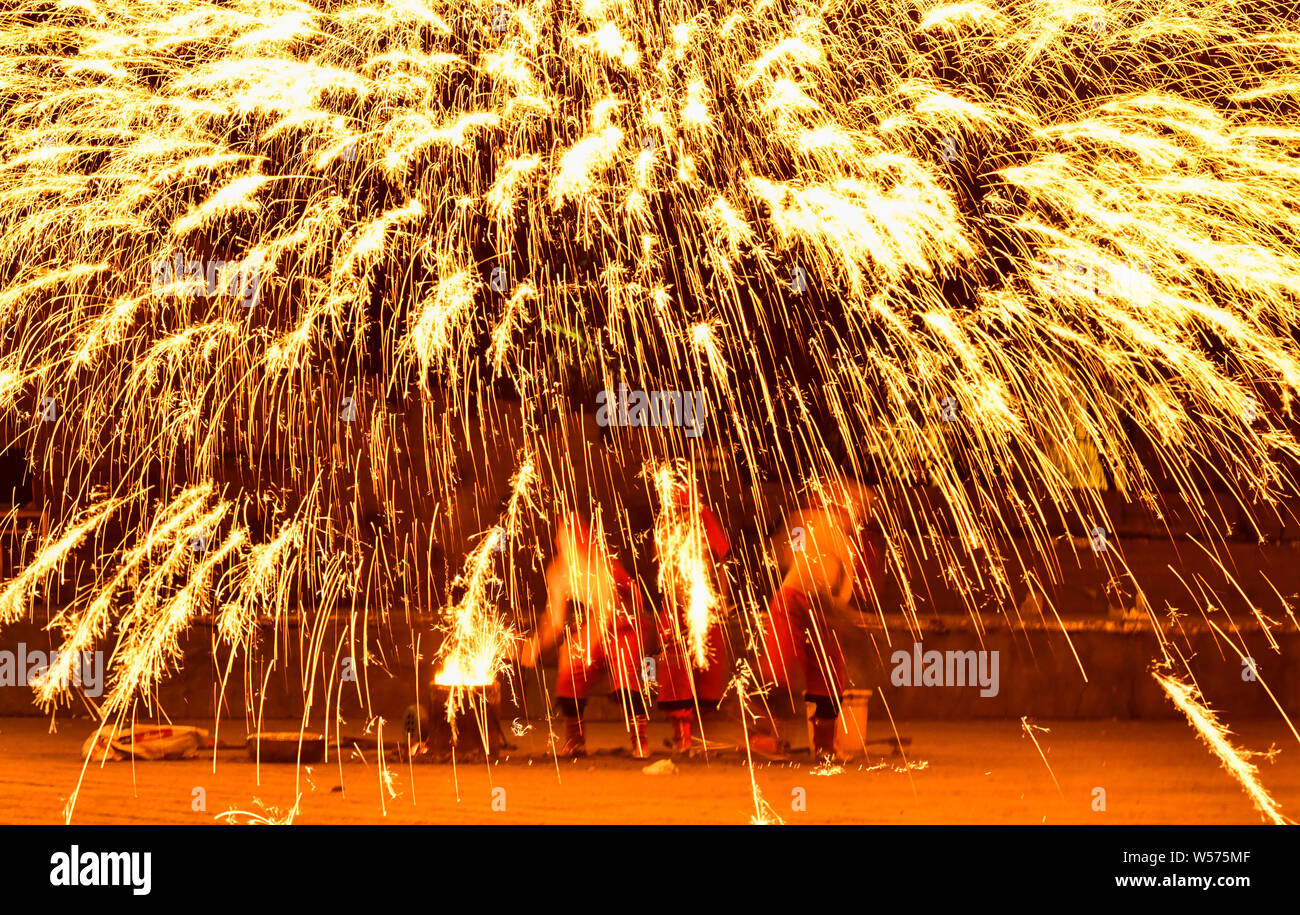 Chinese entertainers perform a fire dragon dance in a shower of molten ...
