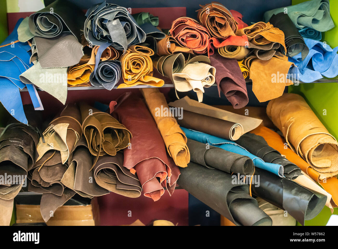 Many rolls leather on shelf in leather workshop Stock Photo - Alamy