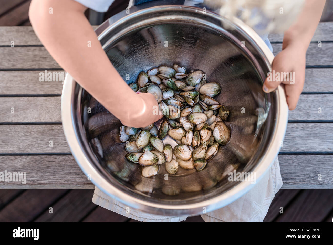 Toddler holding a large bowl of fresh shellfish Stock Photo - Alamy