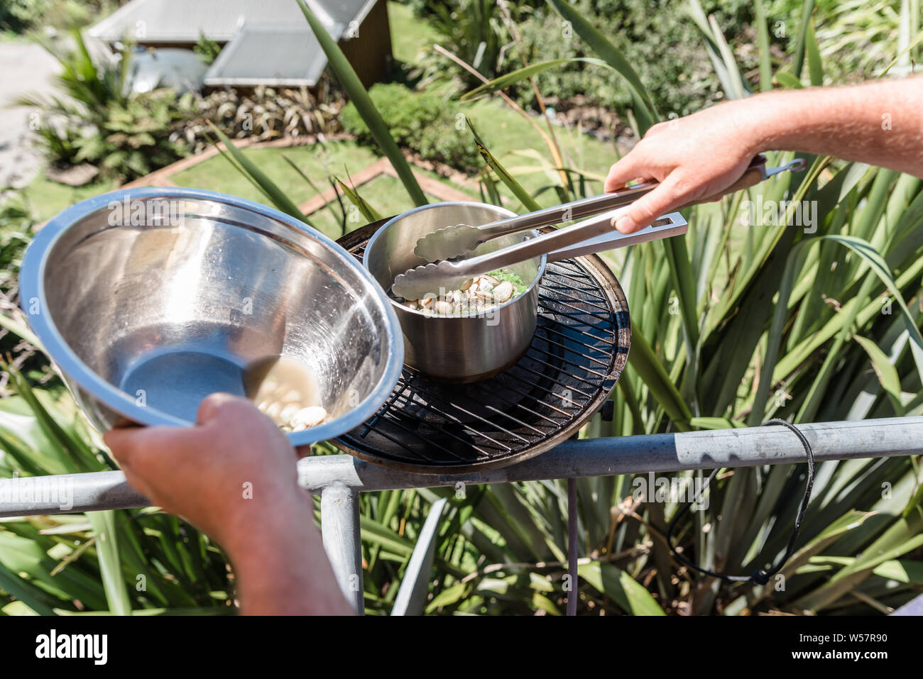 Above view of man preparing shellfish on a grill Stock Photo - Alamy