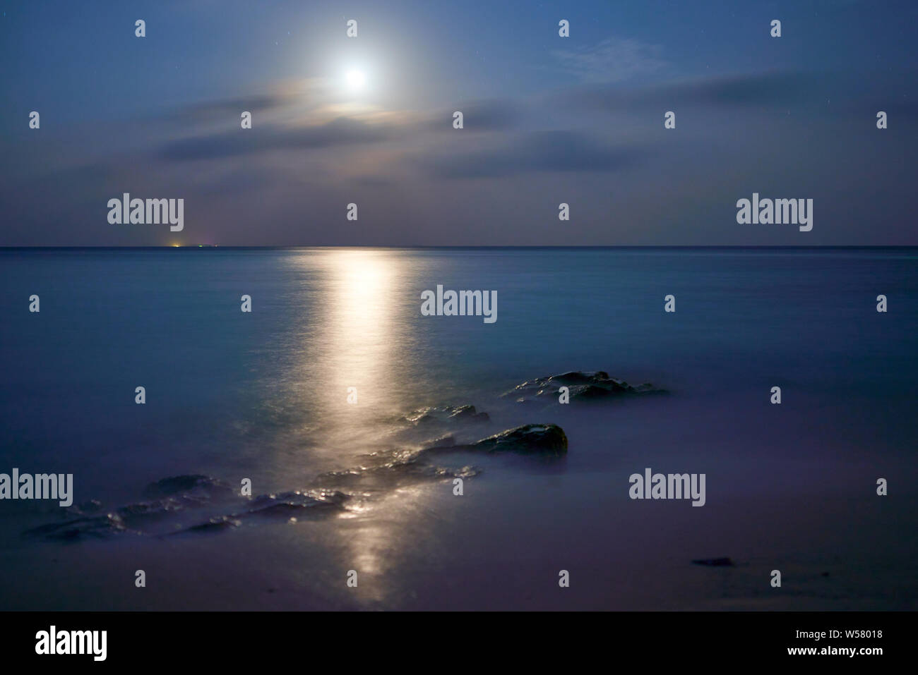 Beautiful sunset, Dark with the moon shinning on the smooth surface of ...