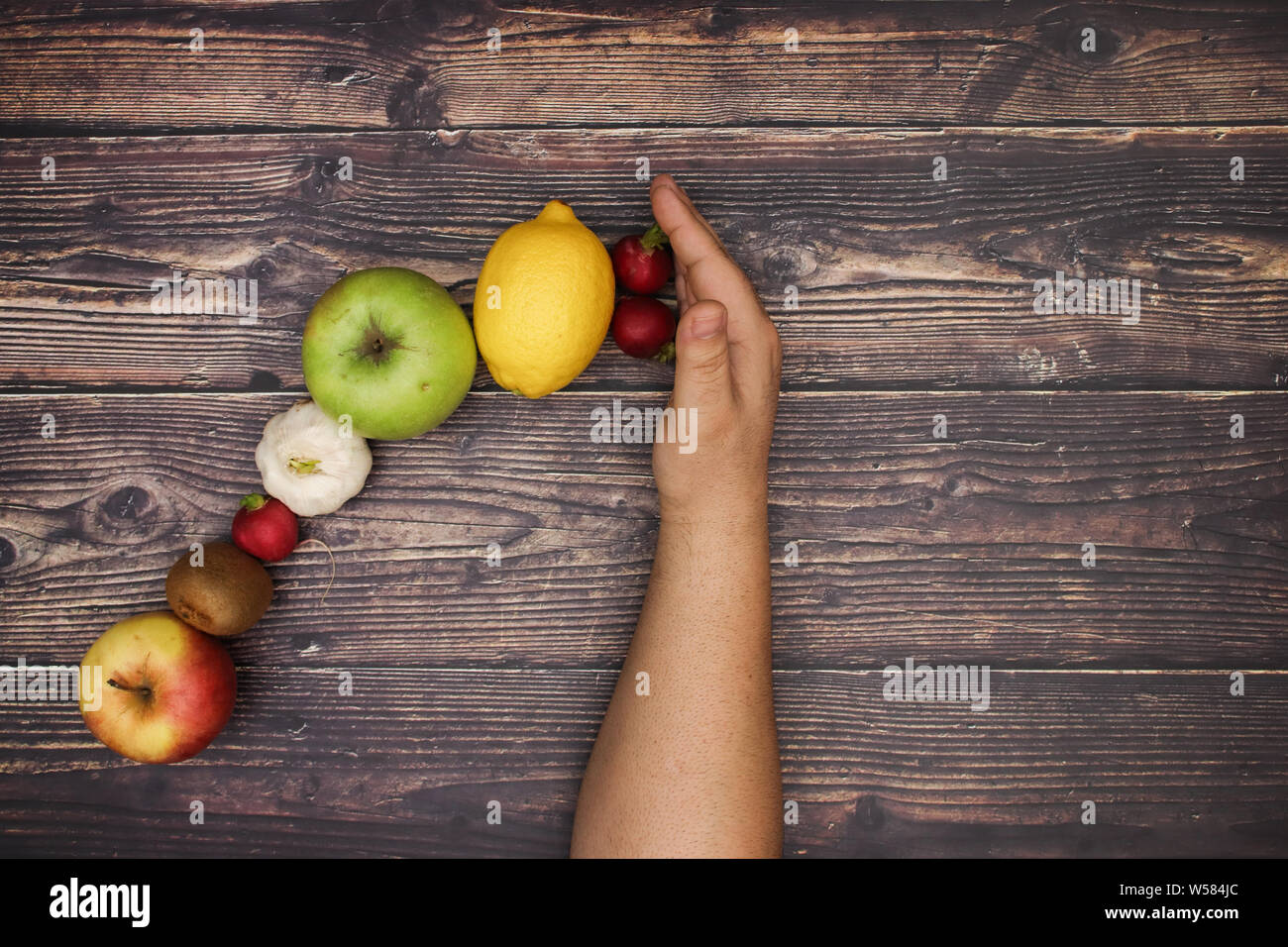 Man's hand and fresh fruits and vegetables behind Stock Photo - Alamy
