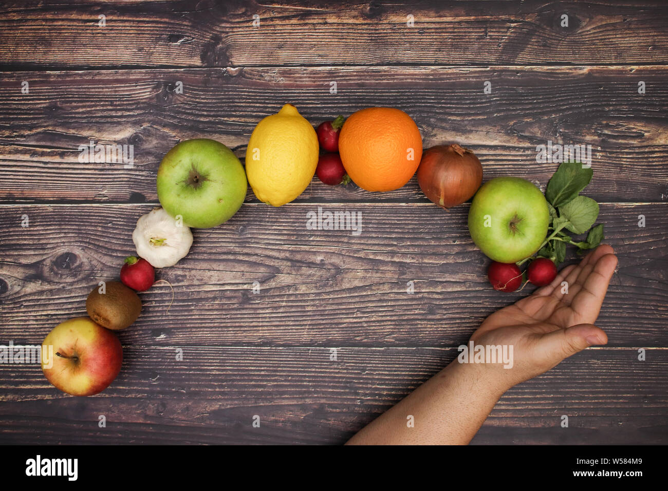 Man's hand and fresh fruits and vegetables behind Stock Photo - Alamy