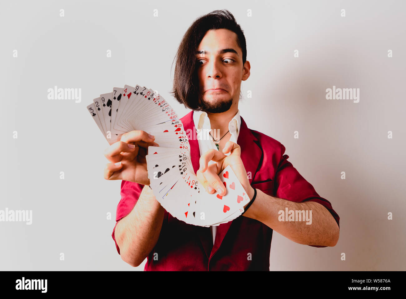 Young magician juggling a deck of playing cards Stock Photo - Alamy