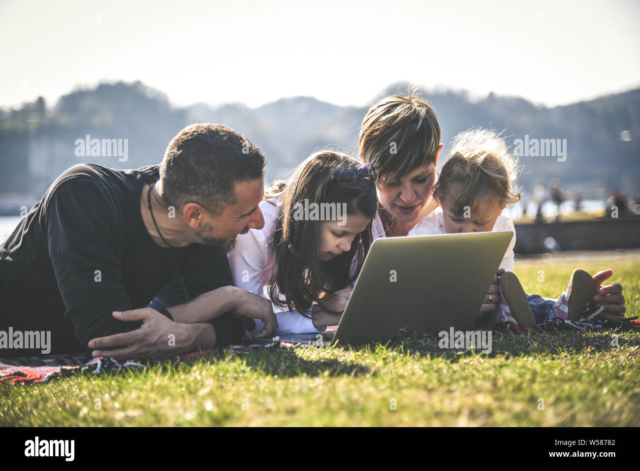 Happy family using laptop computer together garden park summer Kid ...