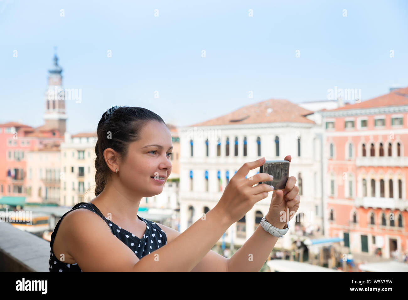 Cheerful Young Woman Clicking Photos On Cellphone In Venice Stock Photo ...