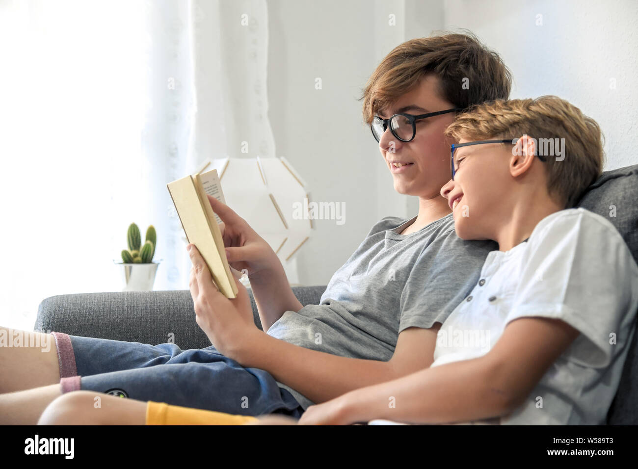 Teen brother reading books to young hi-res stock photography and images ...