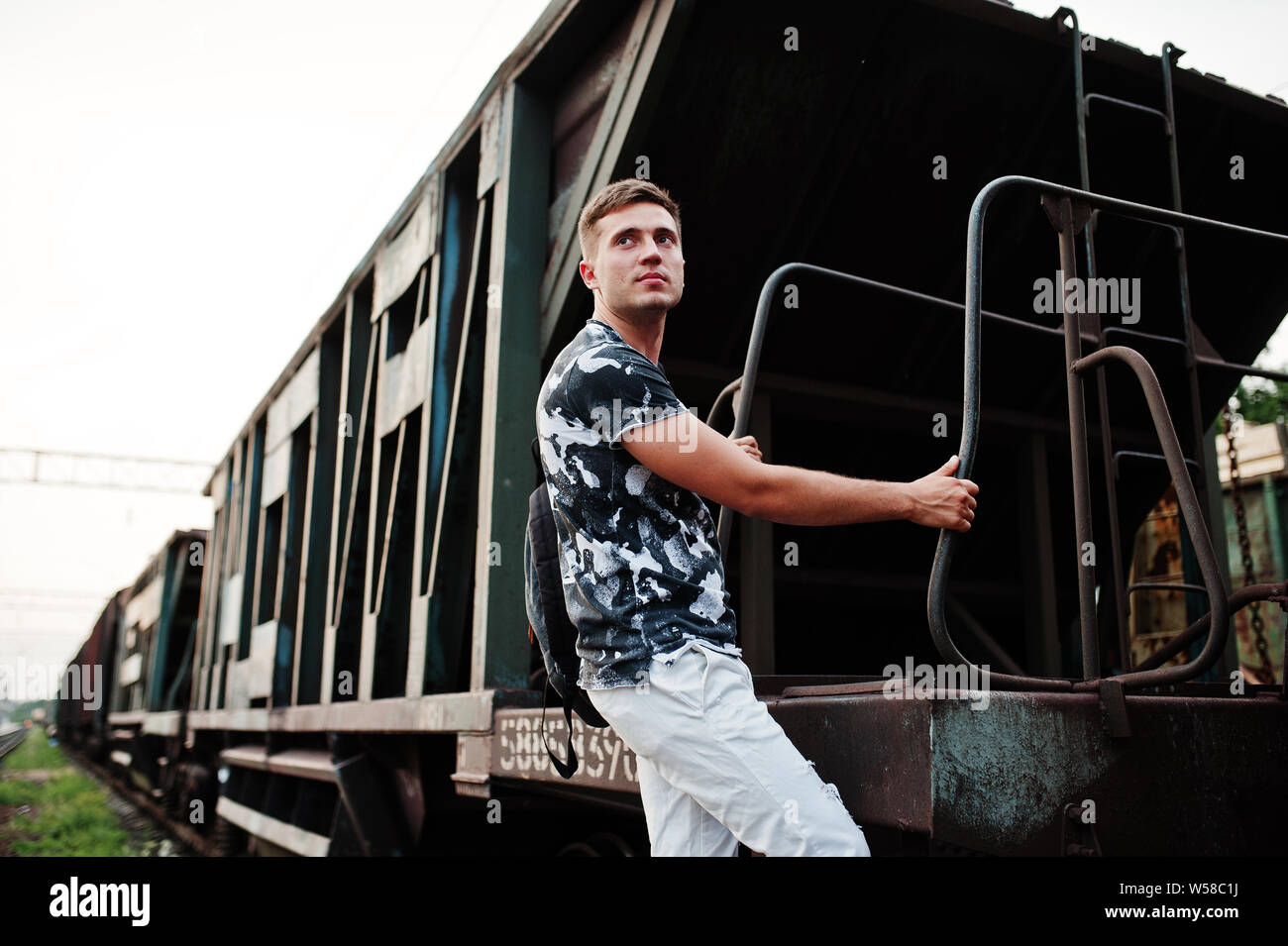 Lifestyle portrait of handsome man posing on train station Stock Photo ...
