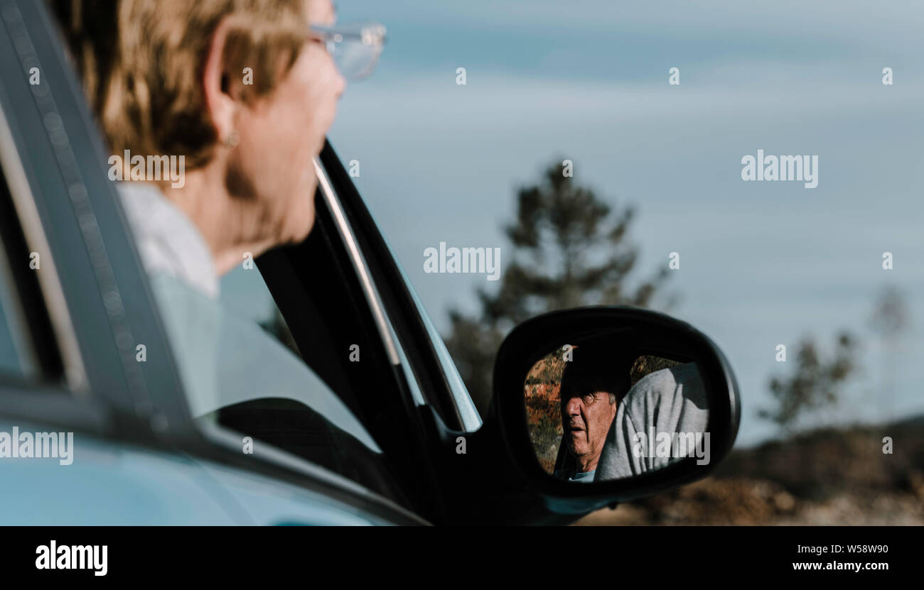 A old woman out of focus with her head out the window and focus on the ...