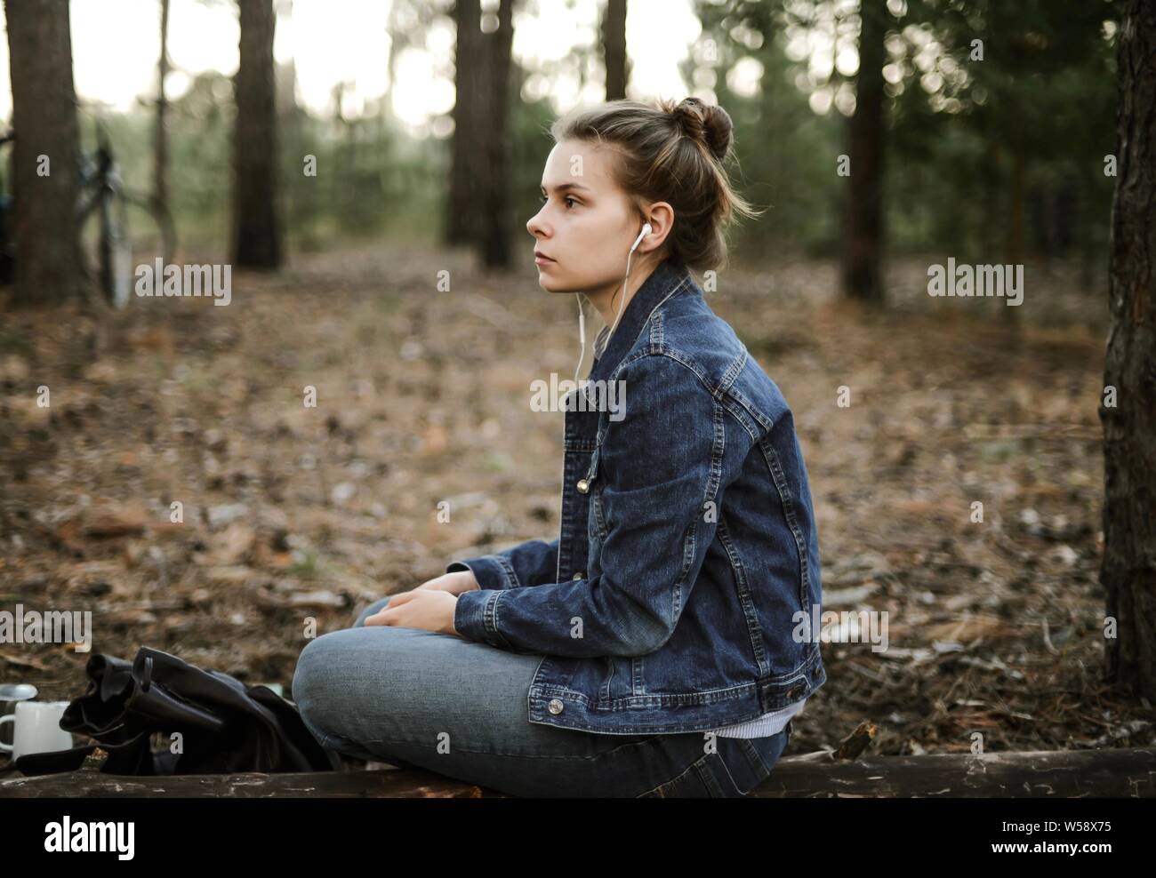 Woman sitting in the forest Stock Photo - Alamy
