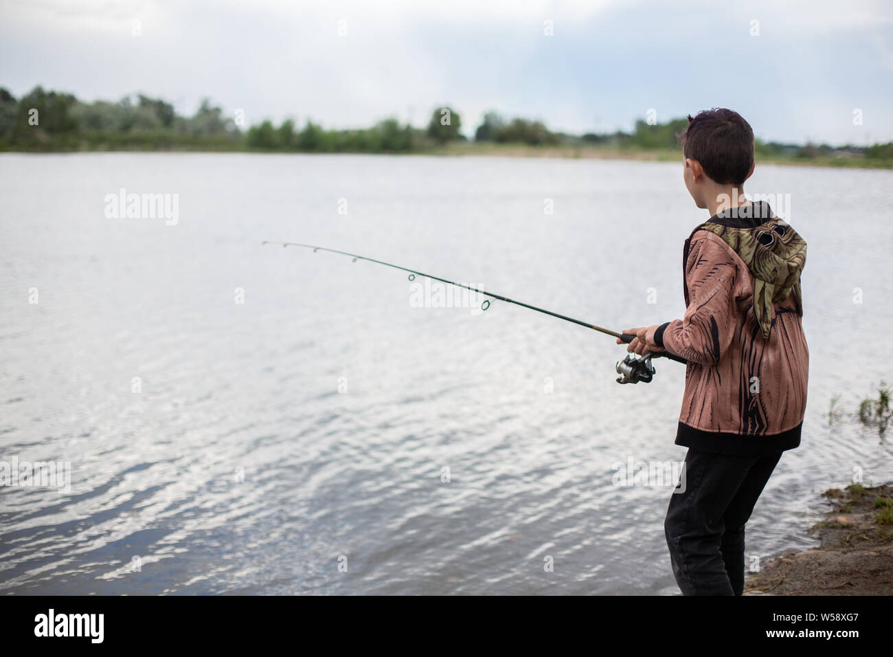 Boy fishing in pond by himself Stock Photo - Alamy