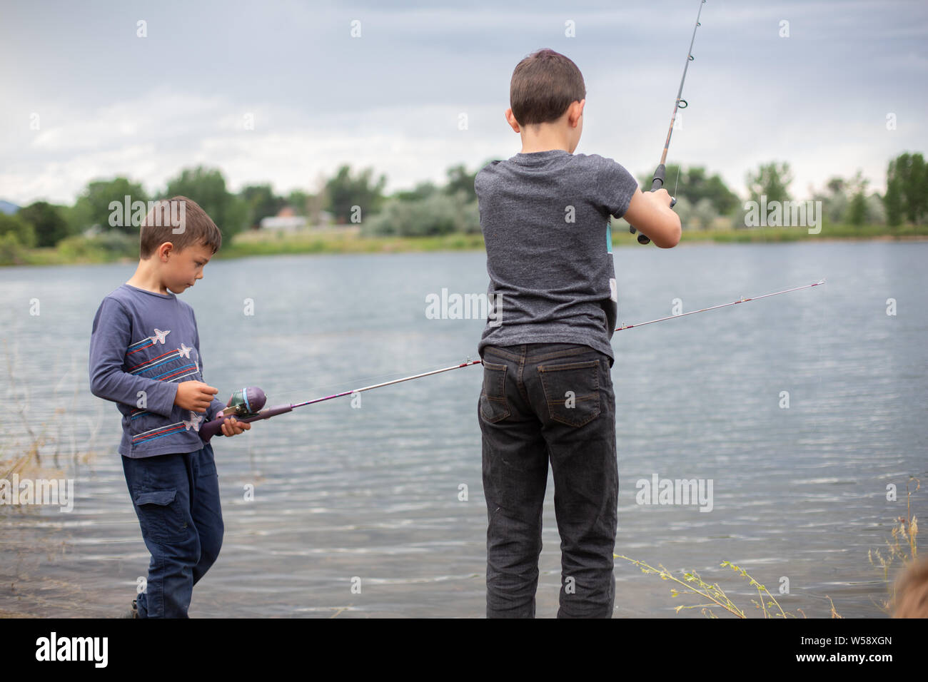 Brothers fishing in a pond Stock Photo - Alamy