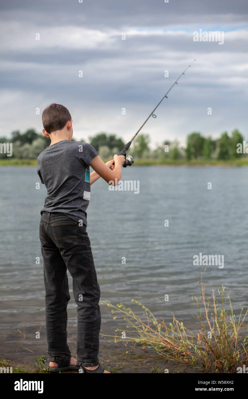 Tween boy fishing in pond Stock Photo - Alamy