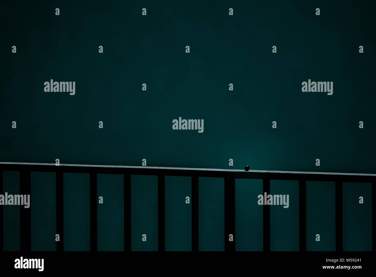 Metal fence with blue background Stock Photo - Alamy