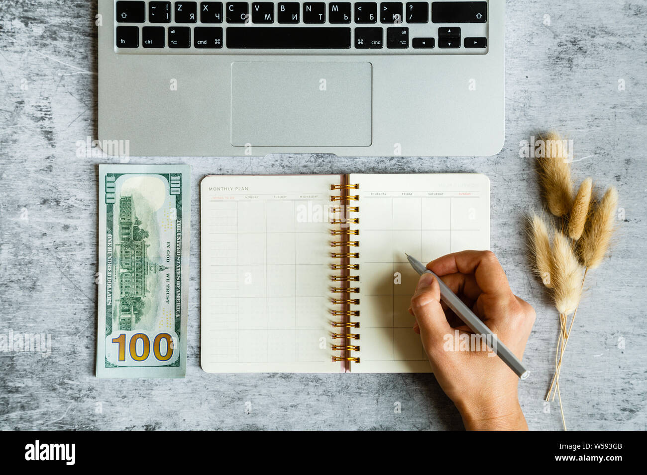 Desktop flatlay: laptop, notebook, woman hands holding pen and typing ...