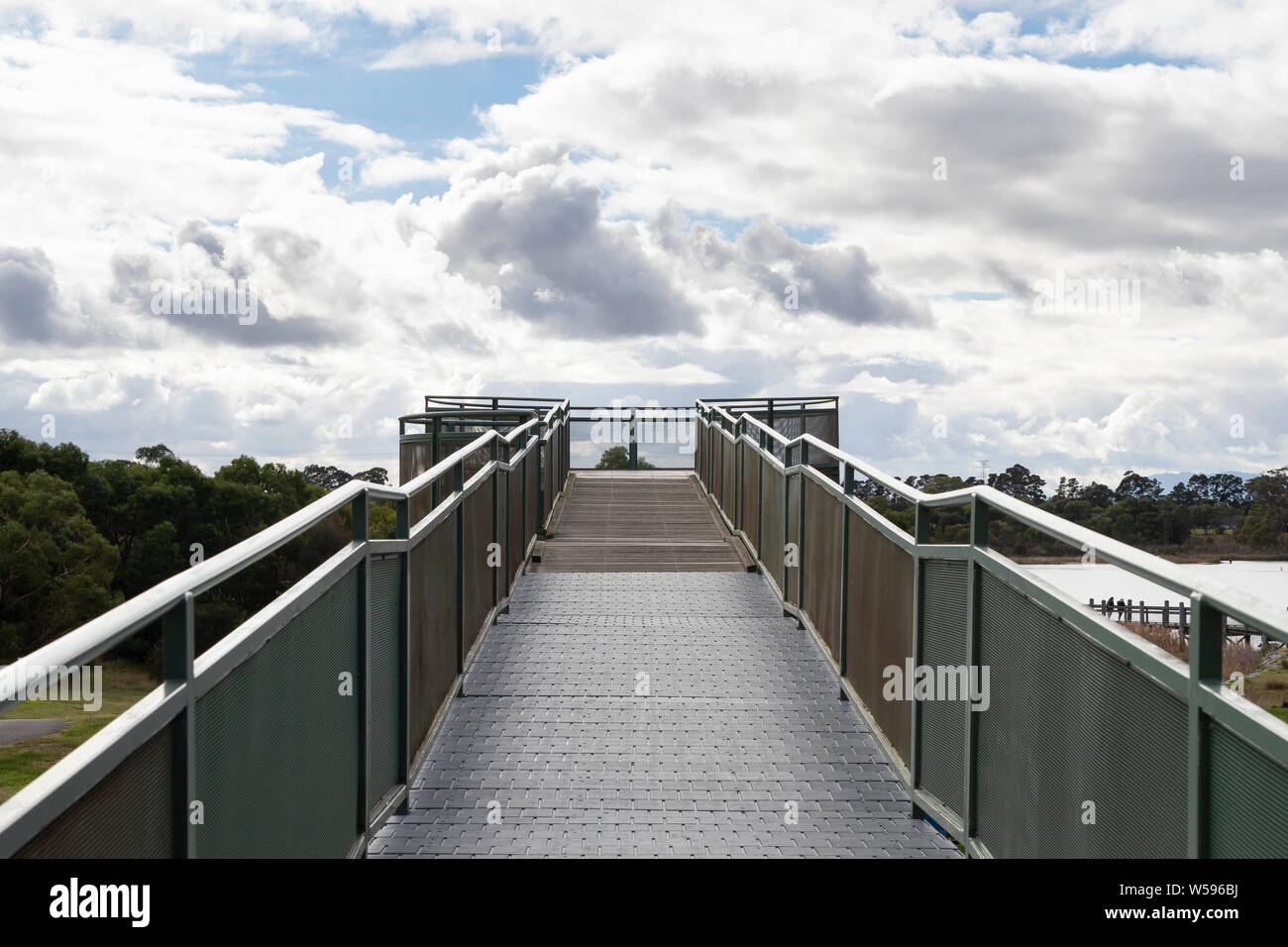 A walkway and viewing platform overlooking a lake in a community park ...