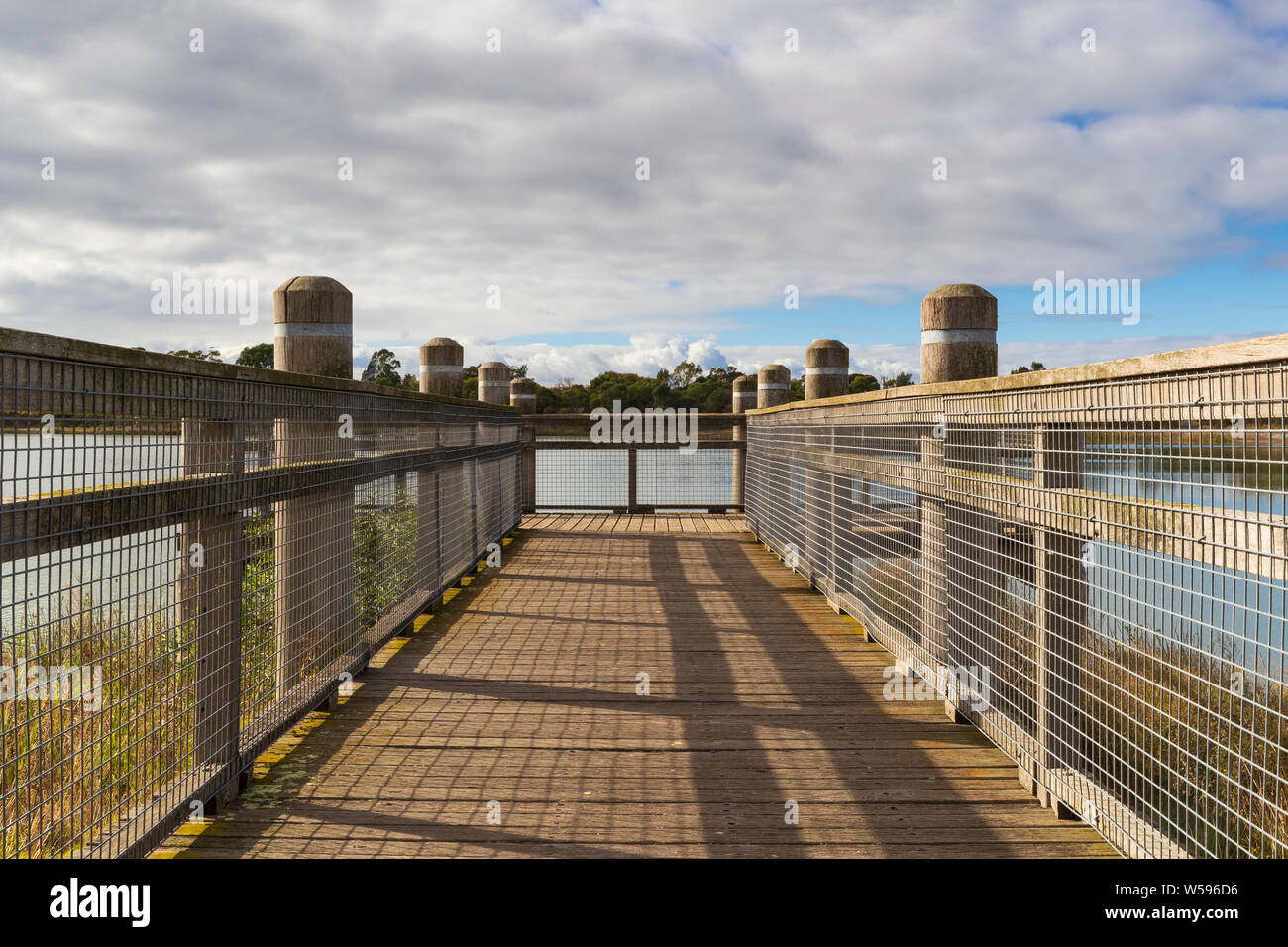 A walkway and viewing platform overlooking a lake in a community park ...
