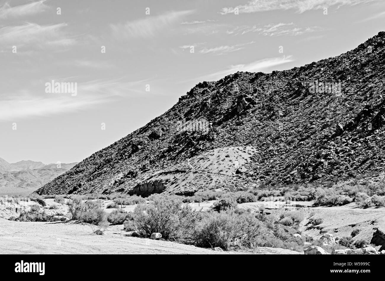 Desert valley with steep rocky hillside, desert bushes and brush Stock ...