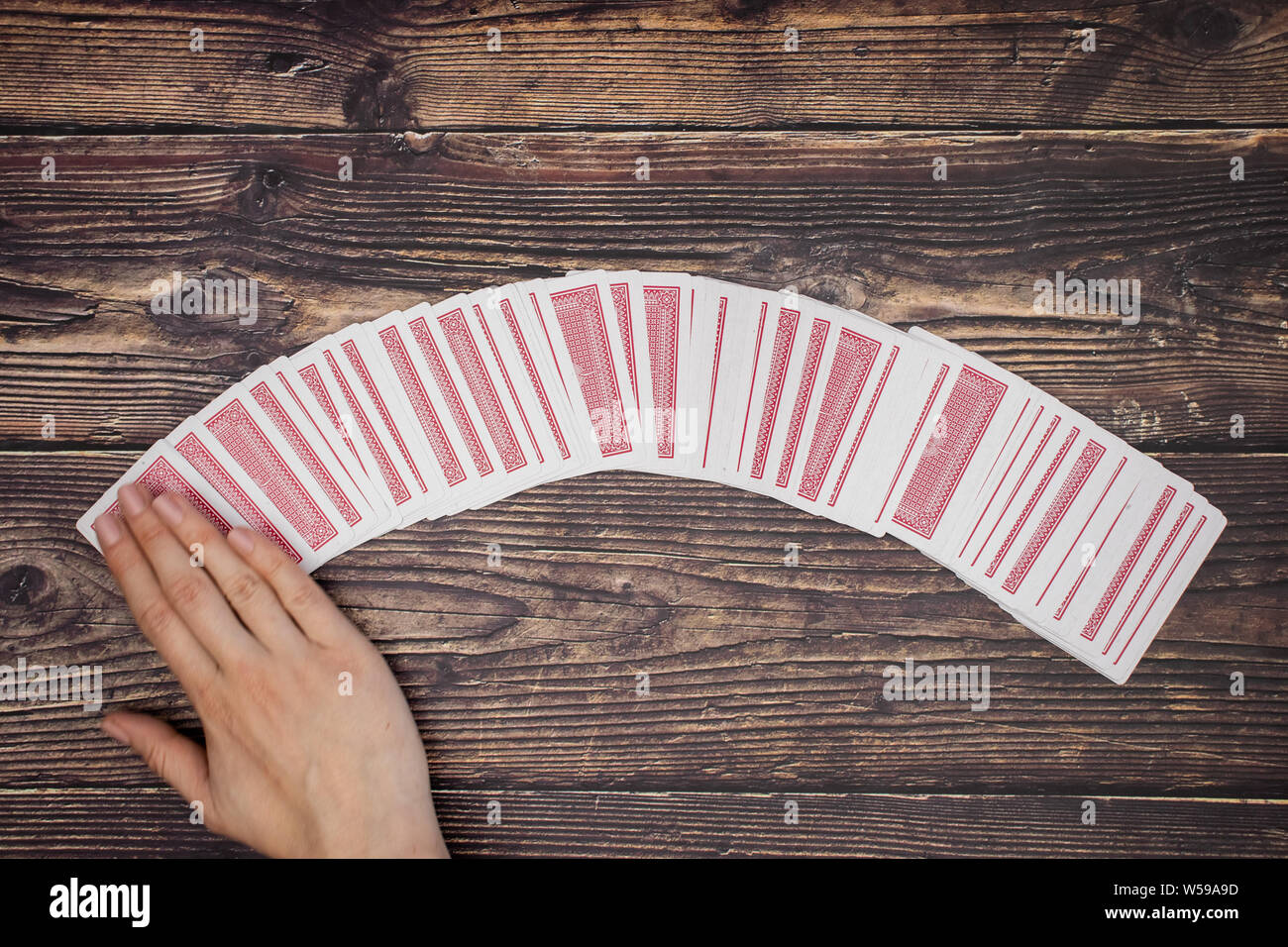 Woman's hand on the deck of cards Stock Photo - Alamy