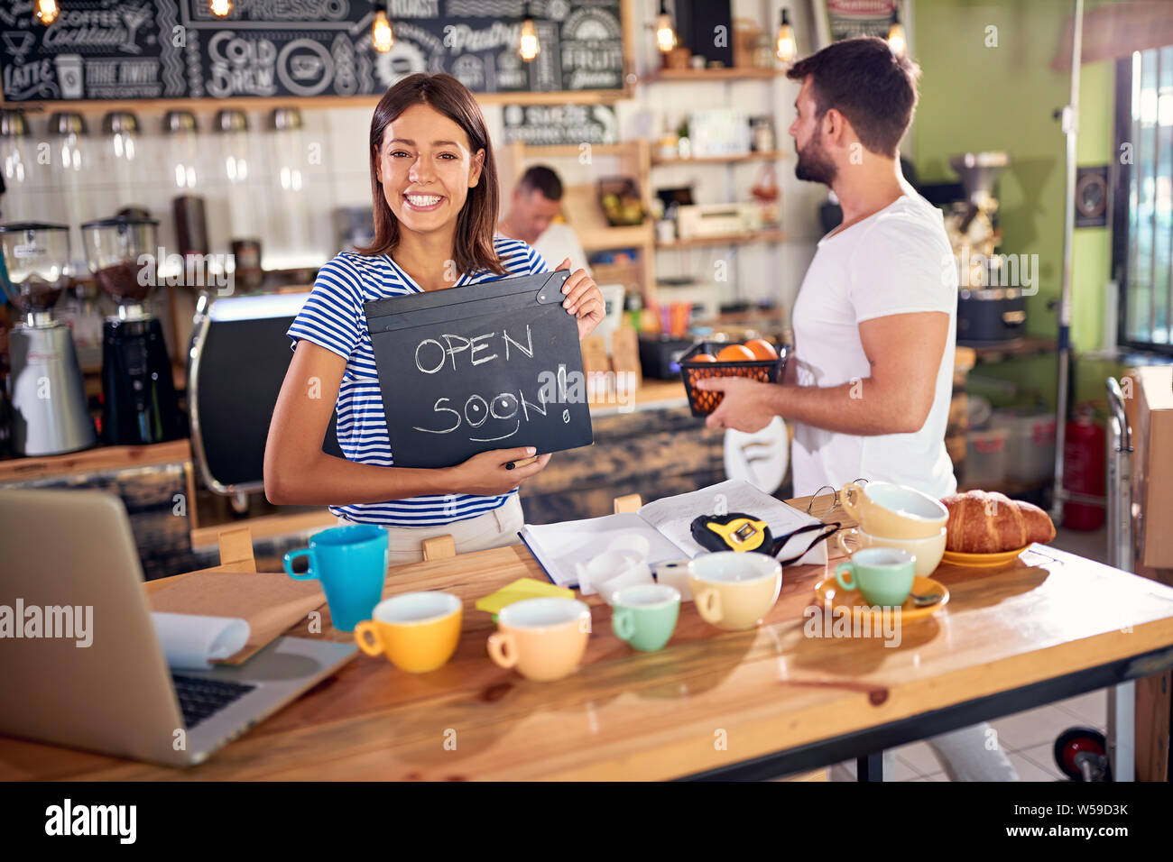 Happy woman store owner with open sign in coffee shop Stock Photo - Alamy