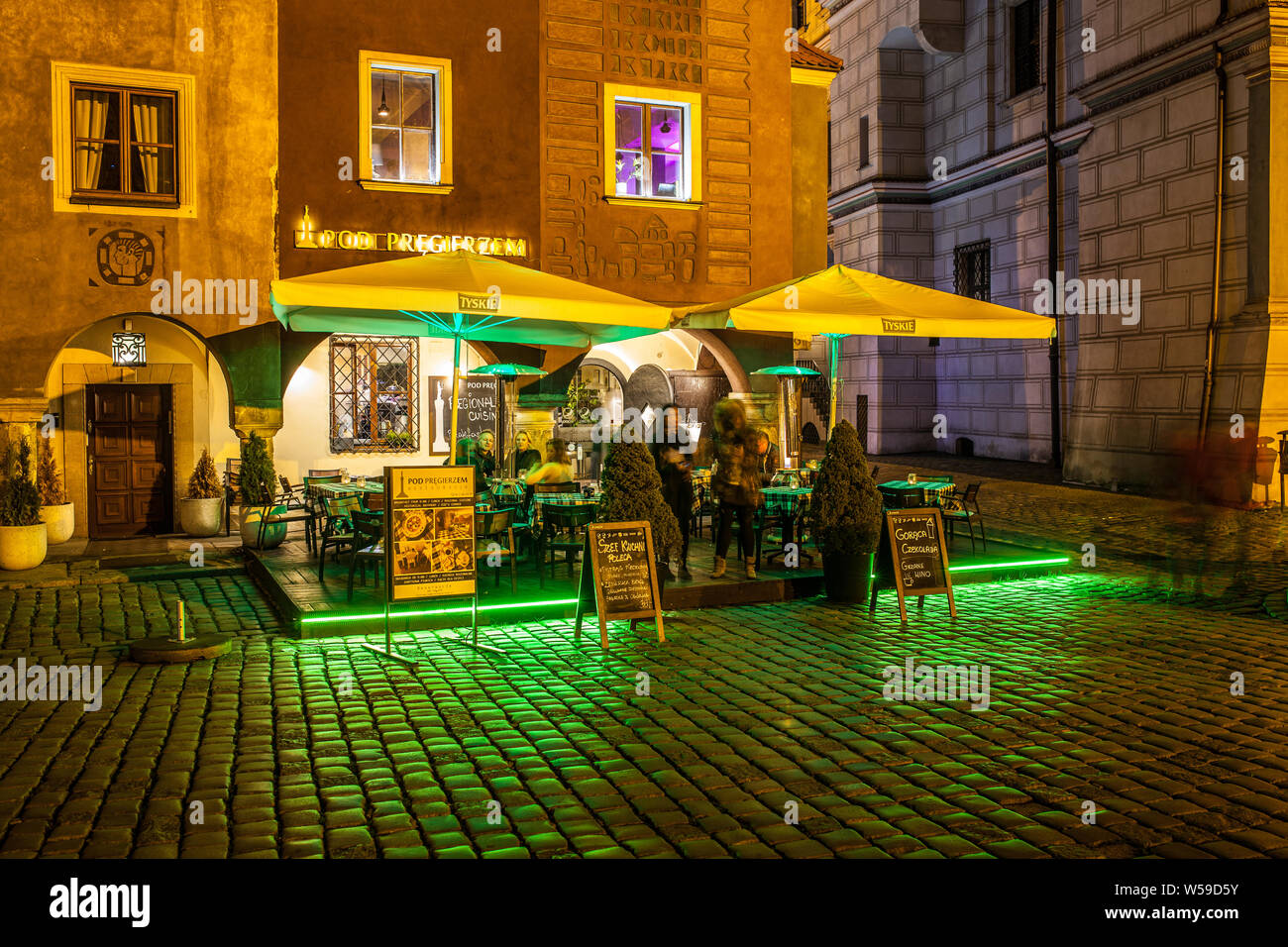 Poznan, Poland, Nov 2017: old Market Square at night, restaurant, bar ...