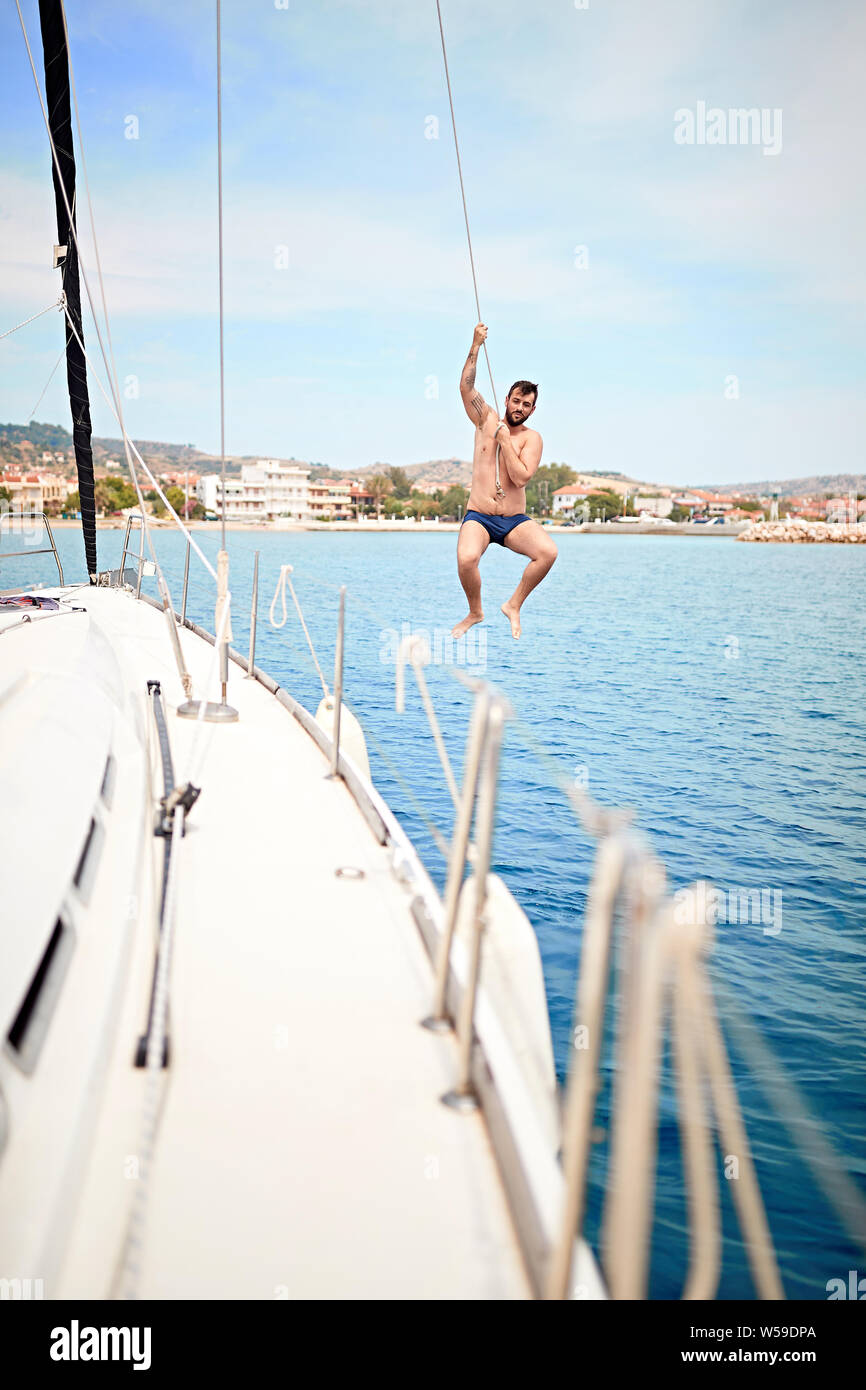 young man hanging out, having fun and enjoying summer days jumping from ...