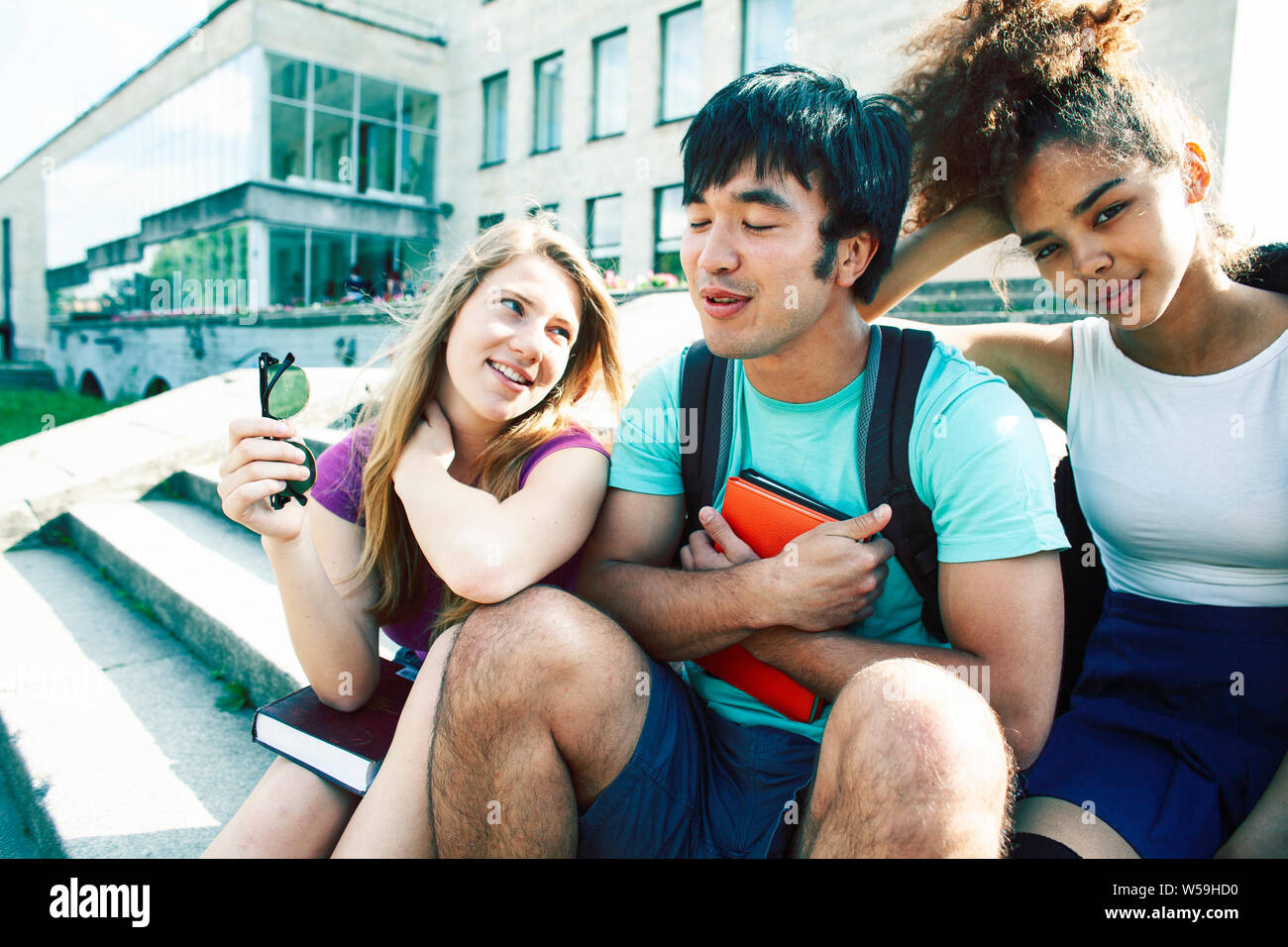 cute group of teenages at the building of university with books ...