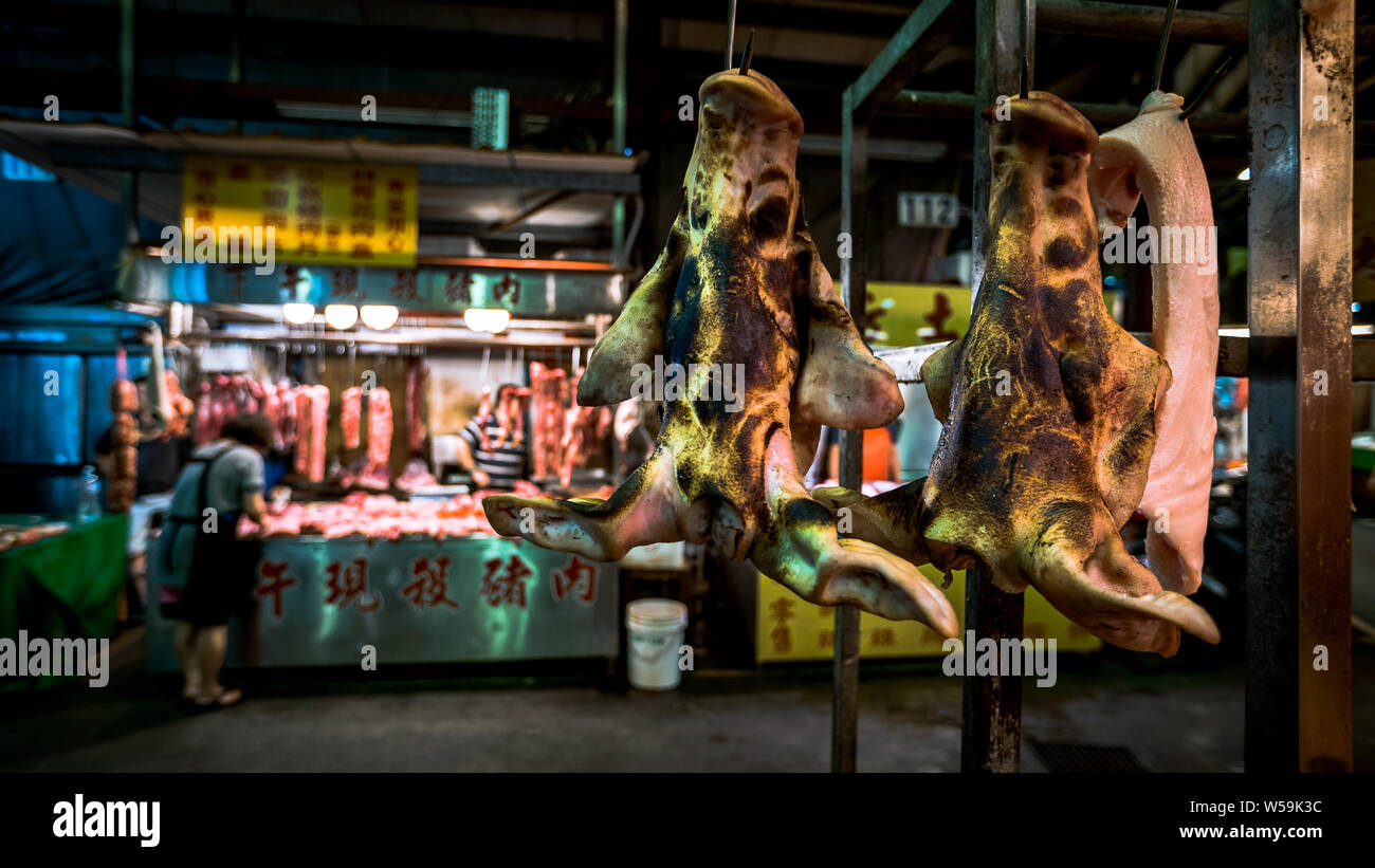 Raw pig face hanging on a hook. Traditional taiwanese food selding in a ...