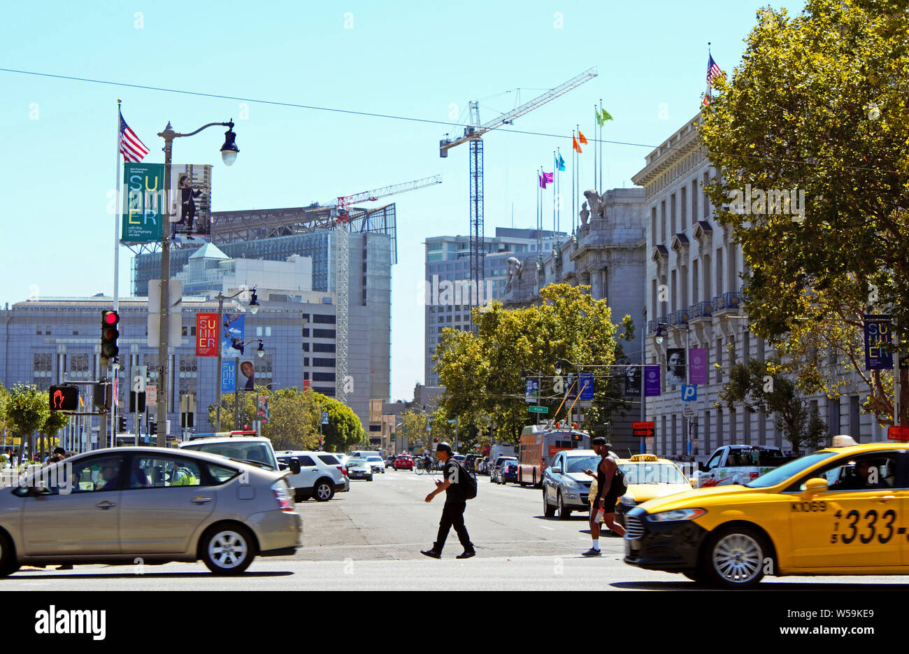 San Francisco street scene with construction cranes in the background ...