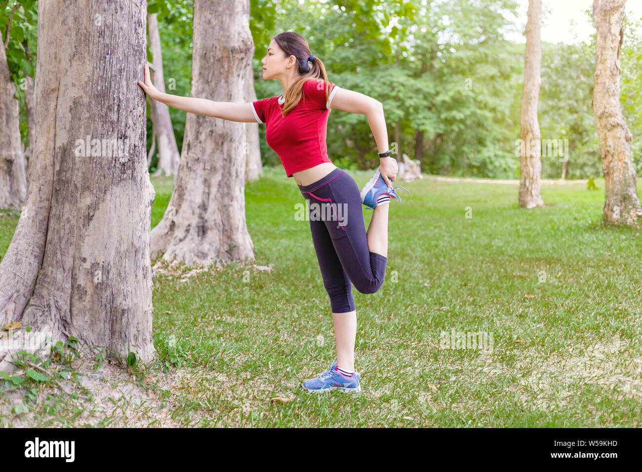 Side view of young athlete woman stretching her leg before and after ...