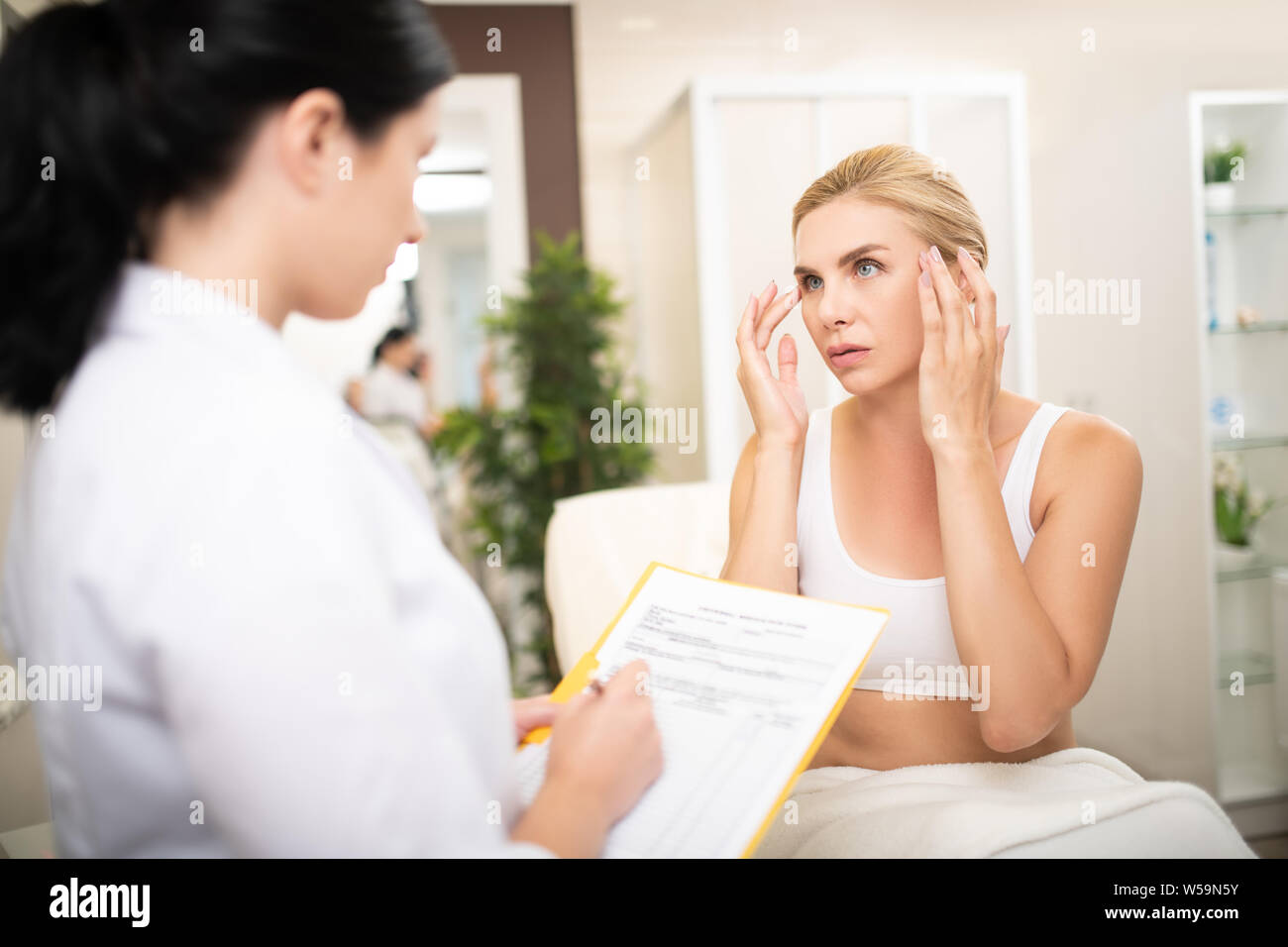 During consultation. Concentrated woman explaining her needs touching ...