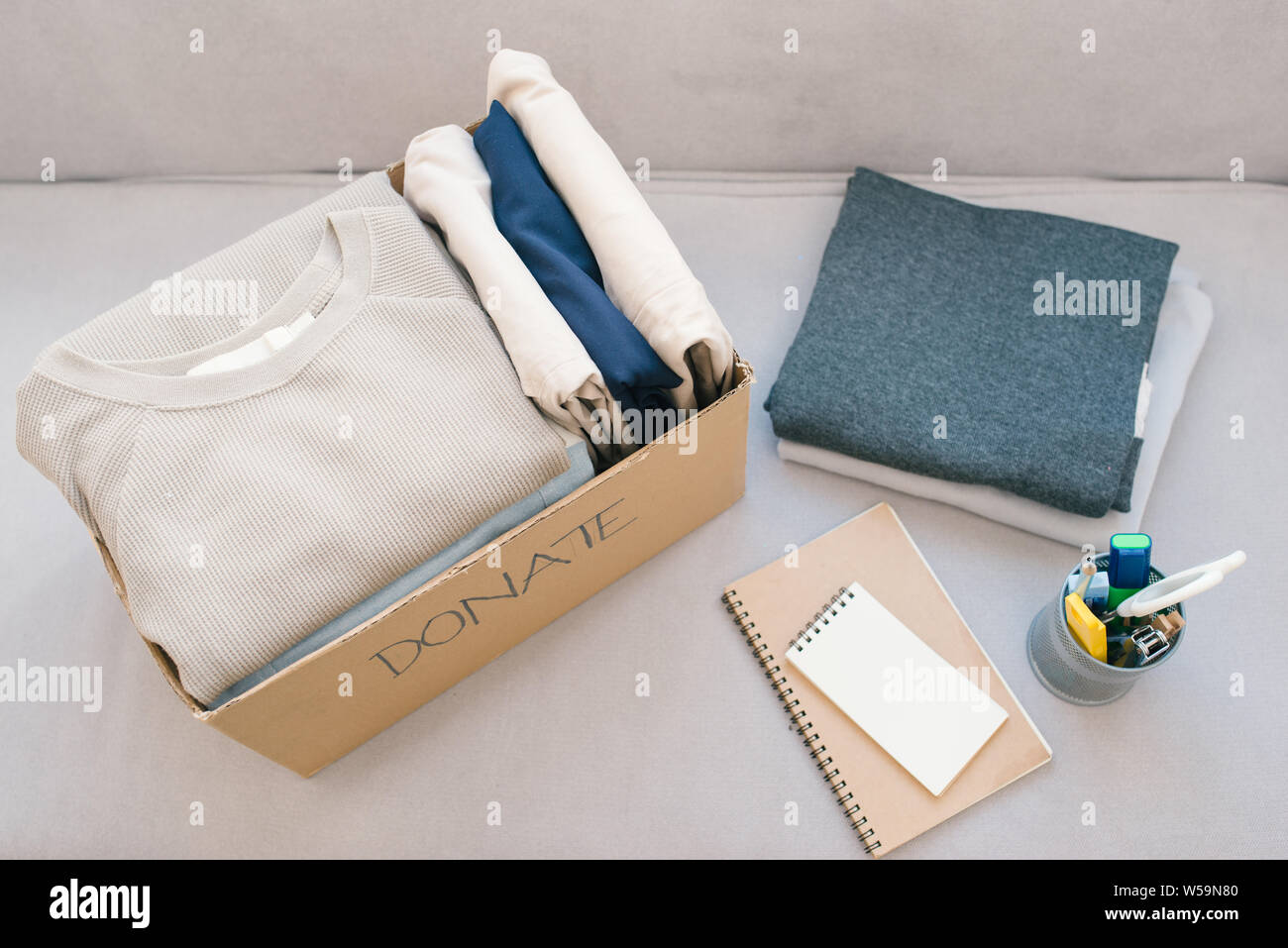 Donation box and casual clothes in livingroom Stock Photo - Alamy