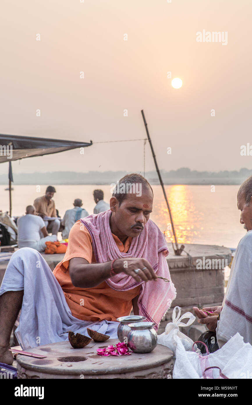 A guru performing a hindu ceremony to local pilgrims at the Ganges ...