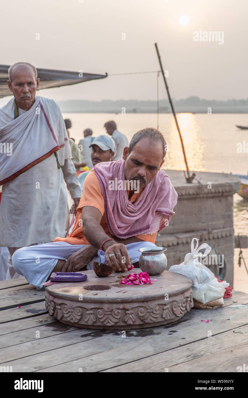 A guru performing a hindu ceremony to local pilgrims at the Ganges ...