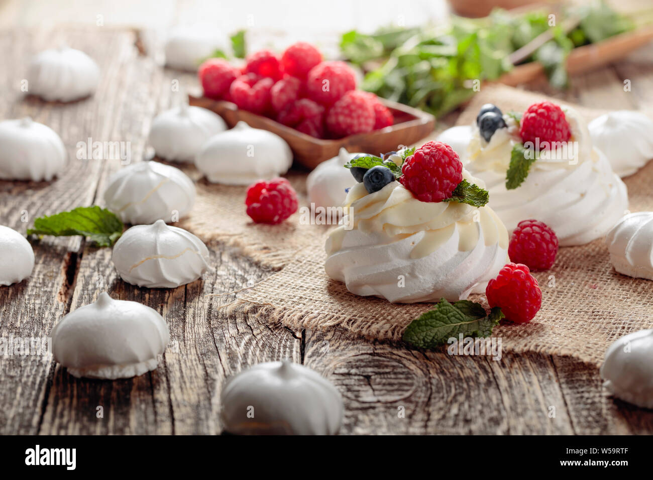 Dessert Pavlova with raspberries, blueberries and mint on a old wooden ...