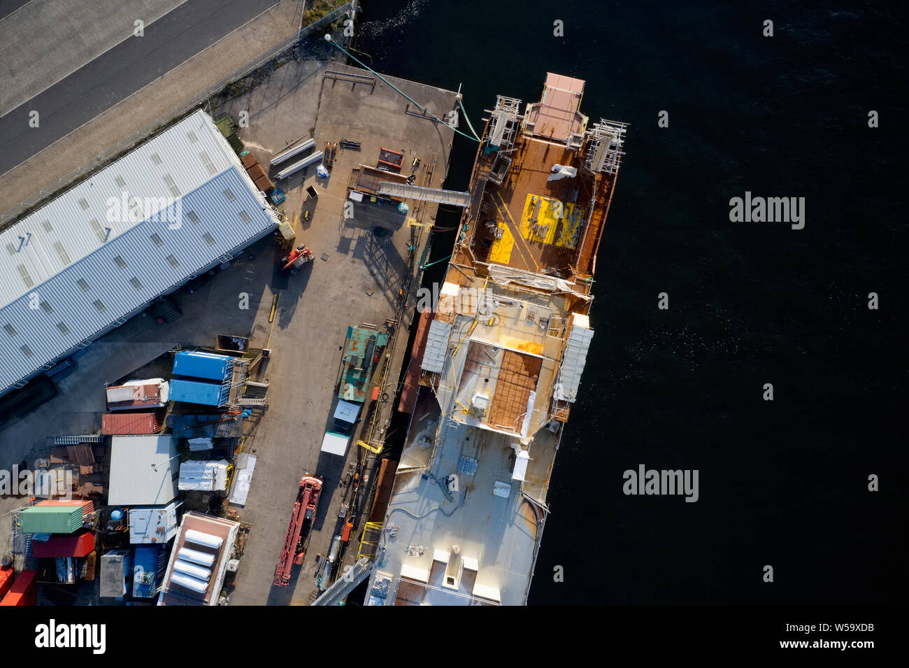 Shipbuilding aerial view at shipyard harbour with ship in construction ...