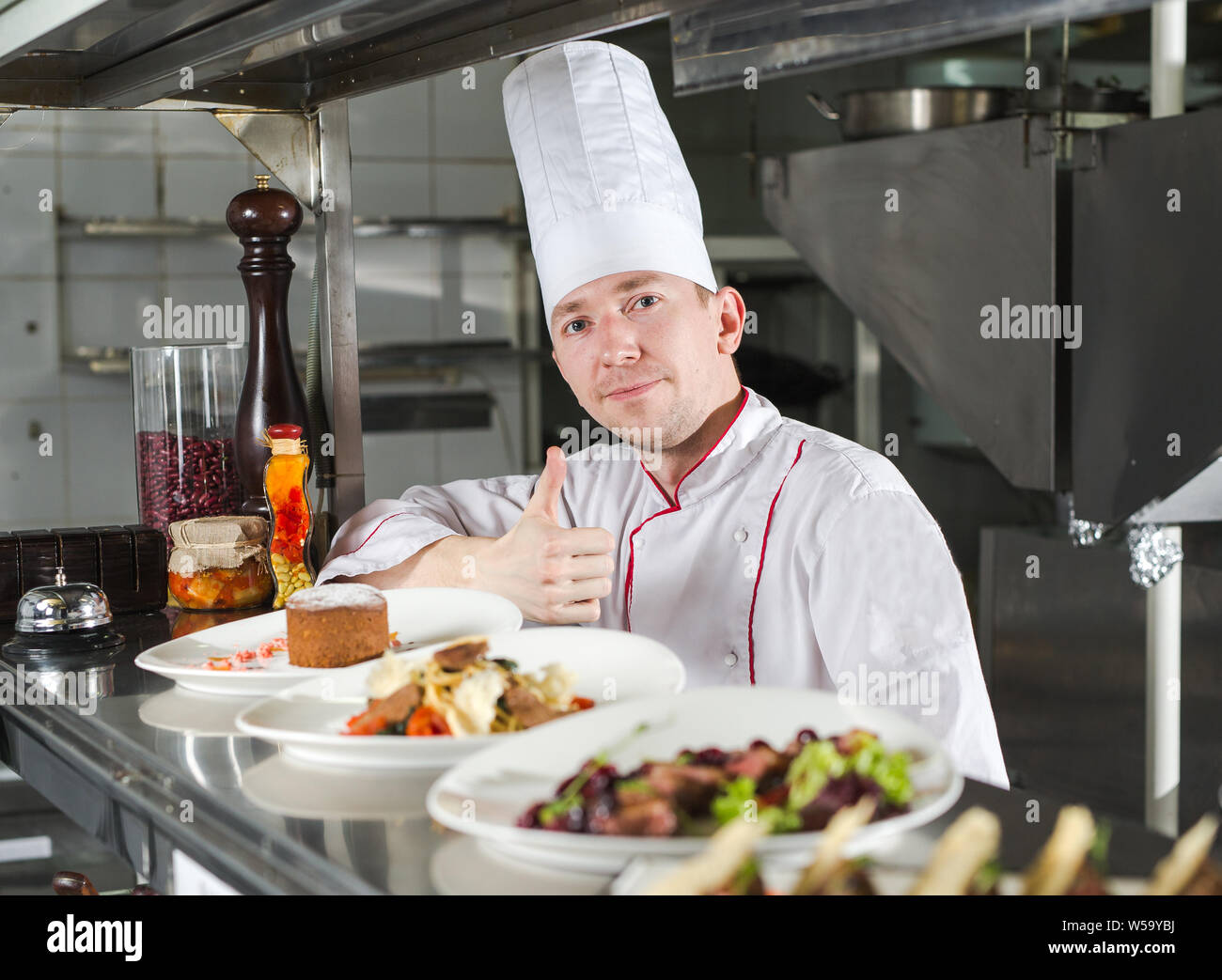 Portrait of a chef with cooked food in the Kitchen in the restaurant ...