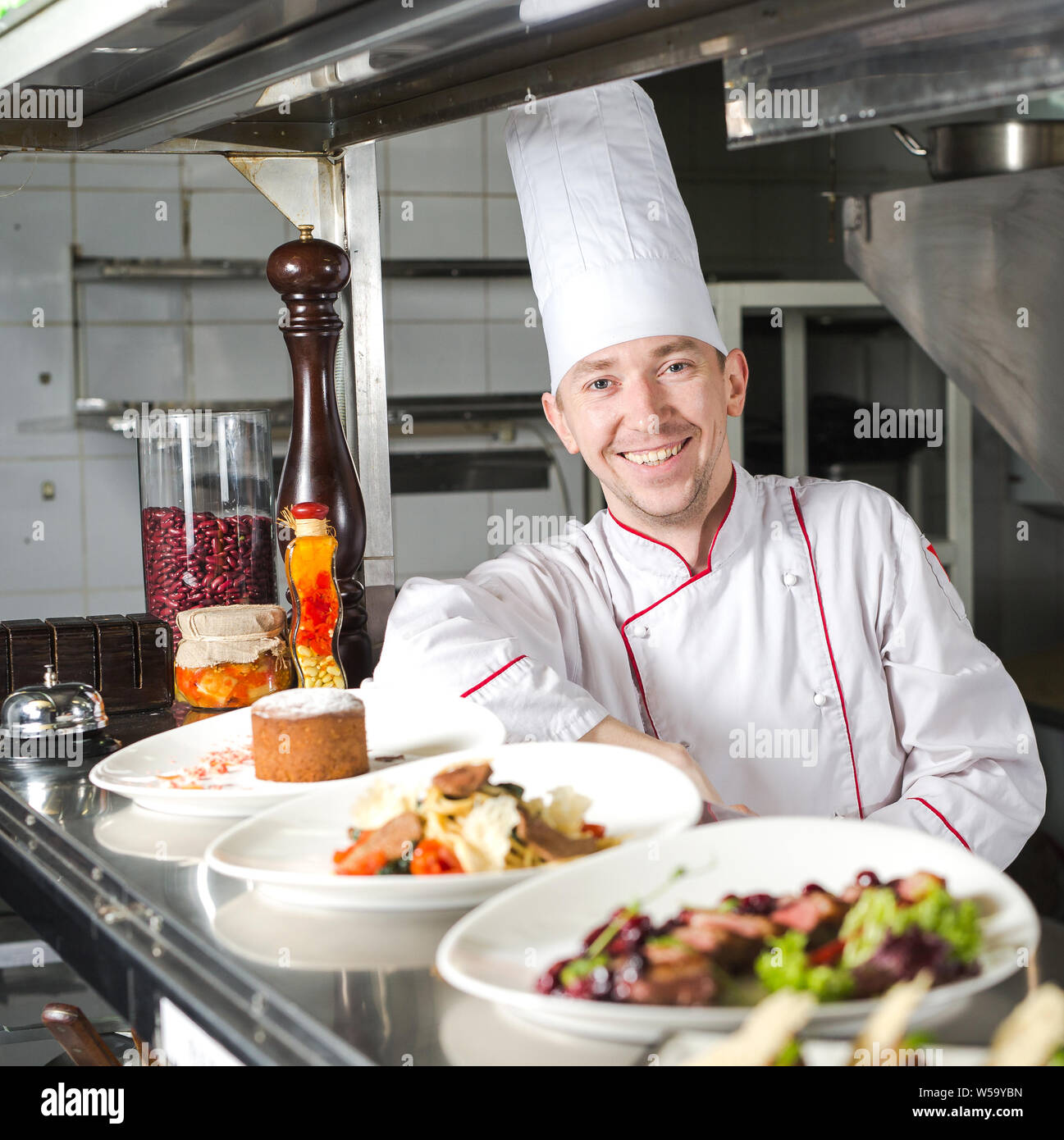 Portrait of a chef with cooked food in the Kitchen in the restaurant ...