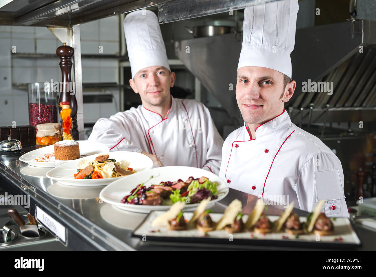 Portrait of a chef with cooked food in the Kitchen in the restaurant ...
