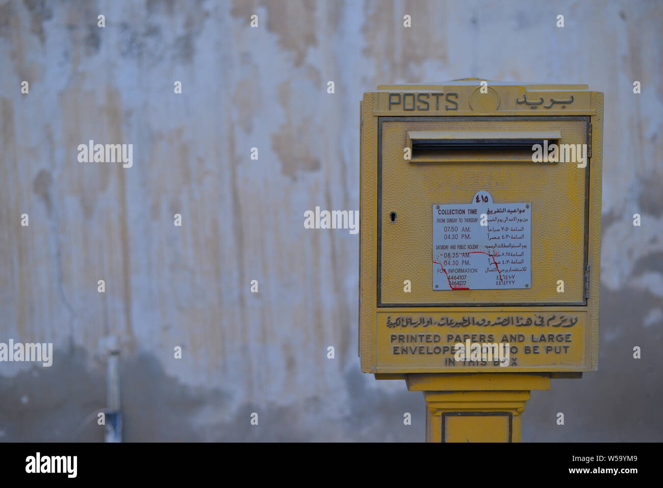 DOHA, QATAR - FEBRUARY 6, 2016: One weathered yellow mailbox in the ...